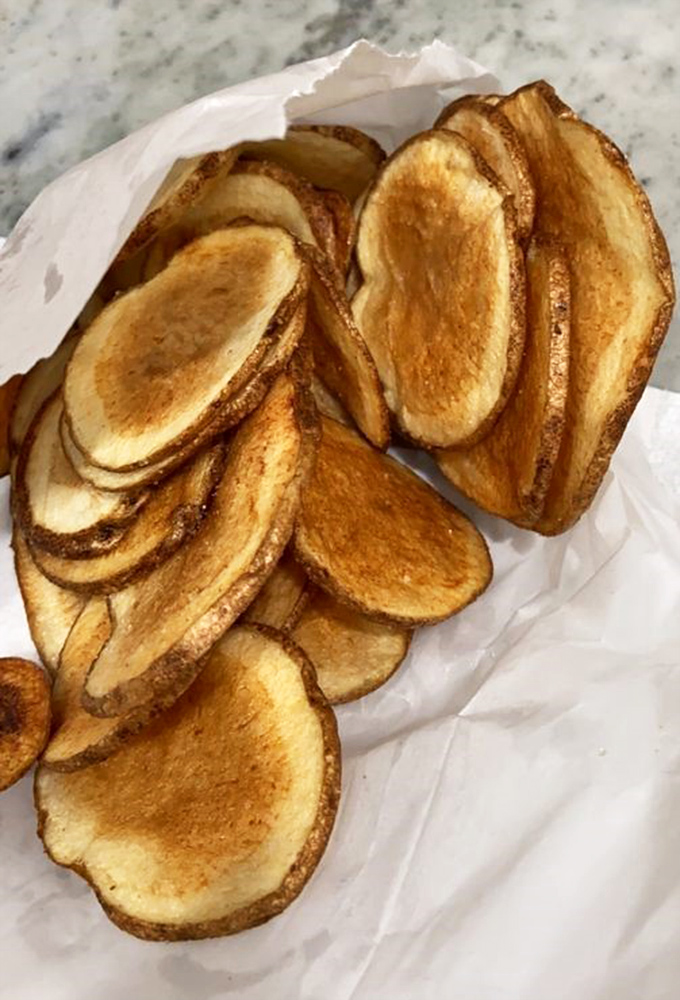 Homemade potato chips that ruin you for the bagged variety forever. Each golden disc is a crispy testament to the power of simple pleasures.