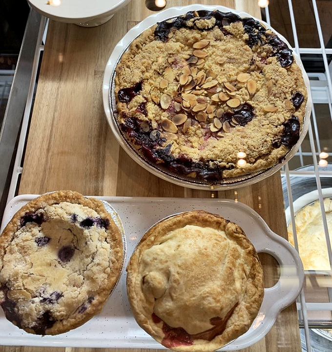 Pie lineup that would make a dessert beauty pageant judge quit on the spot. The crumble-topped berry creation deserves its own trophy.