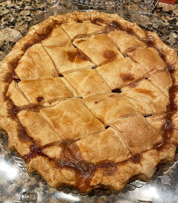 The lattice top on this apple pie isn't just showing off &ndash; it's providing a perfect window into caramelized fruit paradise. Grandma would approve.