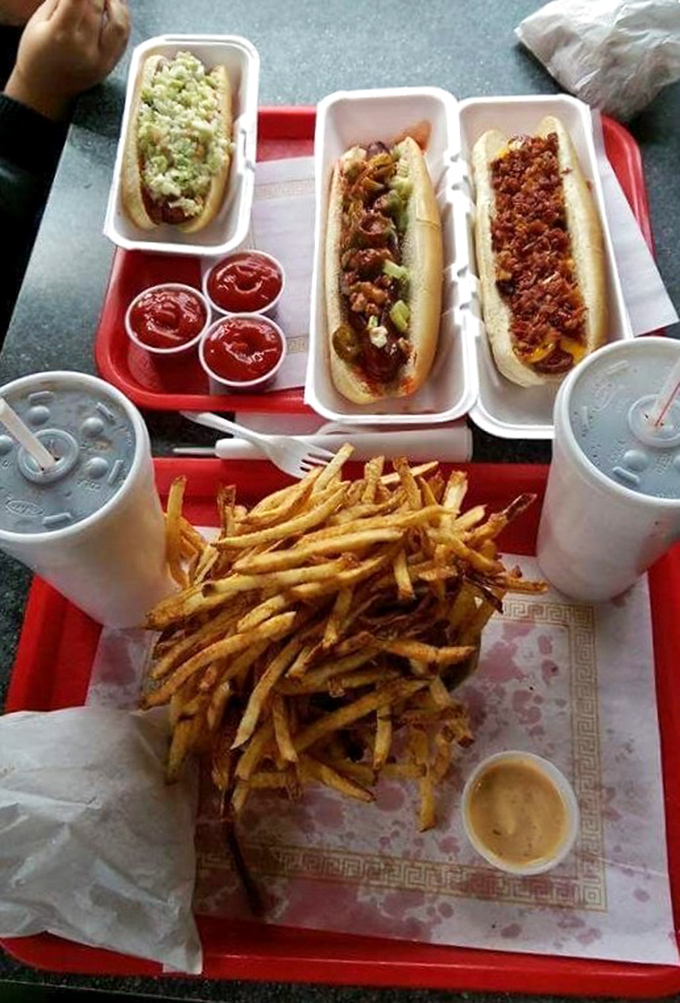 Three perfect dogs with golden fries create a symphony of comfort food excellence.