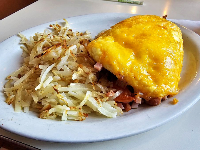 This omelet didn't just break out of its shell&mdash;it found its true calling. Cheese melting over ham with hash browns standing at attention nearby.