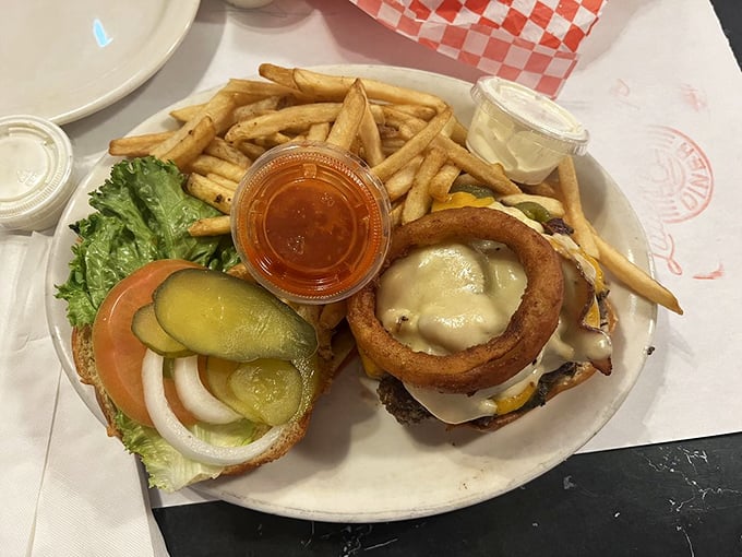 A burger that demands a strategy before the first bite. Melted cheese cascades over the patty while an onion ring crowns this masterpiece.