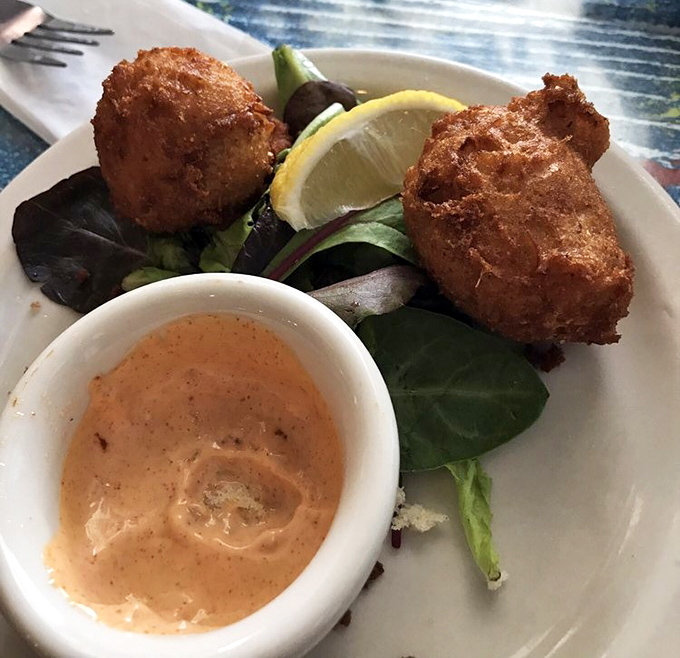 Golden-fried hush puppies with a side of remoulade that's got just enough kick. These crispy orbs of cornmeal joy are the unsung heroes of seafood joints.