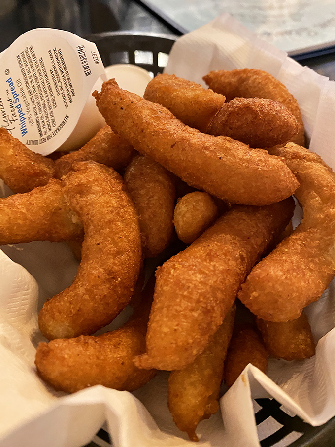 These golden-brown hush puppies aren't just side dishes—they're the main event, with a crispy exterior hiding a tender, slightly sweet cornmeal heart.