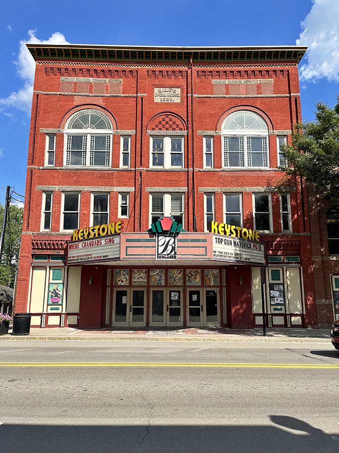 The Keystone Theatre stands as a crimson sentinel of entertainment, its vintage marquee promising small-town movie magic since the early 1900s.