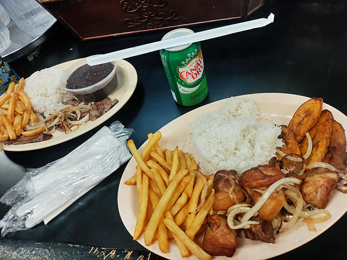 Classic Latin comfort food: perfectly cooked rice, crispy French fries, and seasoned meat topped with onions – a plate that satisfies on a cellular level.