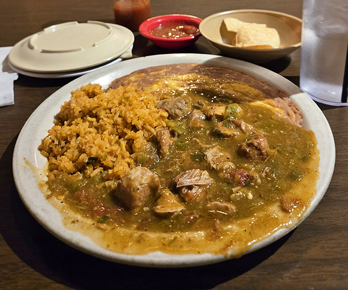 Machaca plate showcases tender shredded beef swimming in that signature green chili sauce alongside perfectly seasoned Mexican rice.