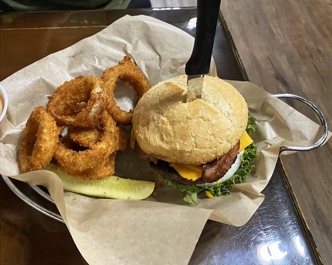A burger that requires both hands and possibly a nap afterward. That melted cheese cascading down the sides is nature's perfect waterfall.