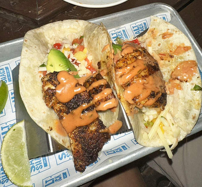 Mahi tacos with that perfect char, dressed in a sauce that would make even plain toast taste magnificent.