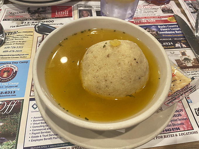 The matzo ball soup &ndash; a golden pool of comfort cradling what might be the fluffiest matzo ball this side of your grandmother's kitchen.