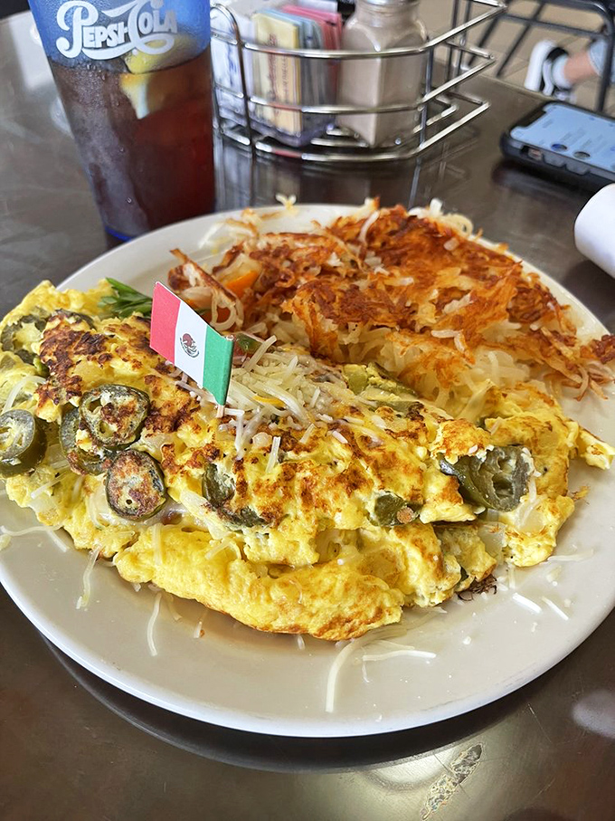 That Mexican omelet with its tiny flag is like a flavor fiesta wrapped in eggs, with crispy hash browns standing at attention nearby.