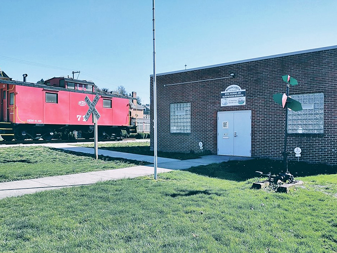 The bright red caboose stands as a cheerful reminder of Brownsville's railroad heritage at the local transportation museum.