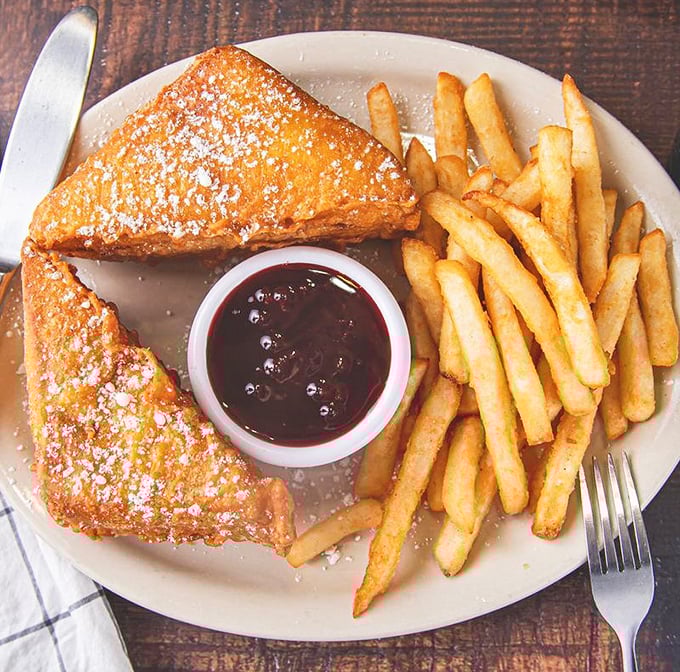 The Monte Cristo: where breakfast and lunch collide in a powdered sugar snowstorm. Crispy, sweet, savory&mdash;a holy trinity of flavor.