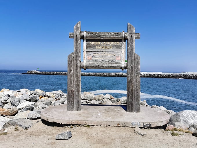 Harbor history written in wood and water. This weathered sign marks the entrance to a working port where authenticity hasn't been polished away by tourism.