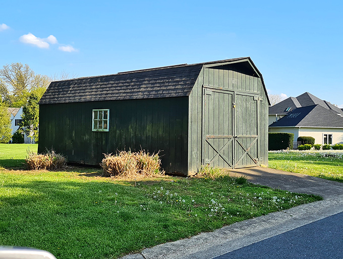 The surrounding countryside features charming structures that complement the bridge's rustic appeal, like this classic Pennsylvania barn.