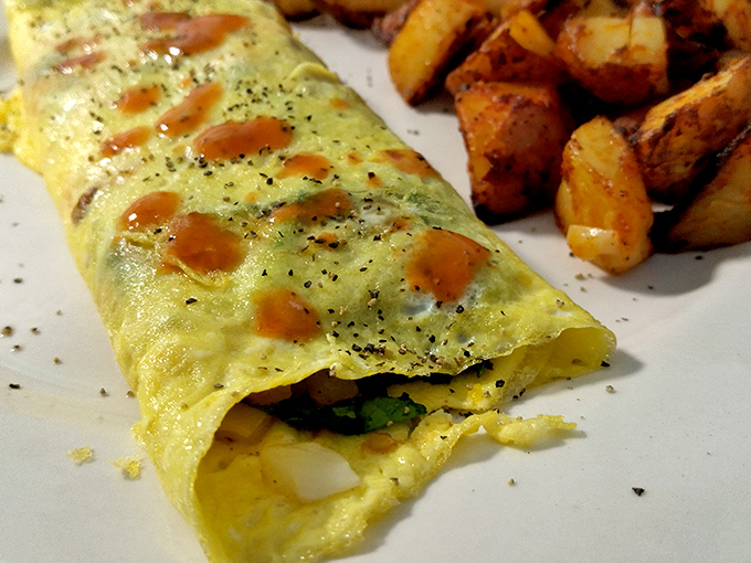 An omelet that's seen things, been places, and picked up flavors along the way. Paired with home fries that could make a potato proud.