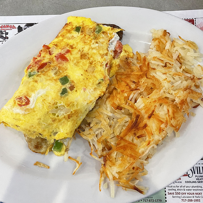 Sunshine on a plate! This golden omelet studded with colorful vegetables pairs perfectly with hash browns that crackle with each delicious forkful. 