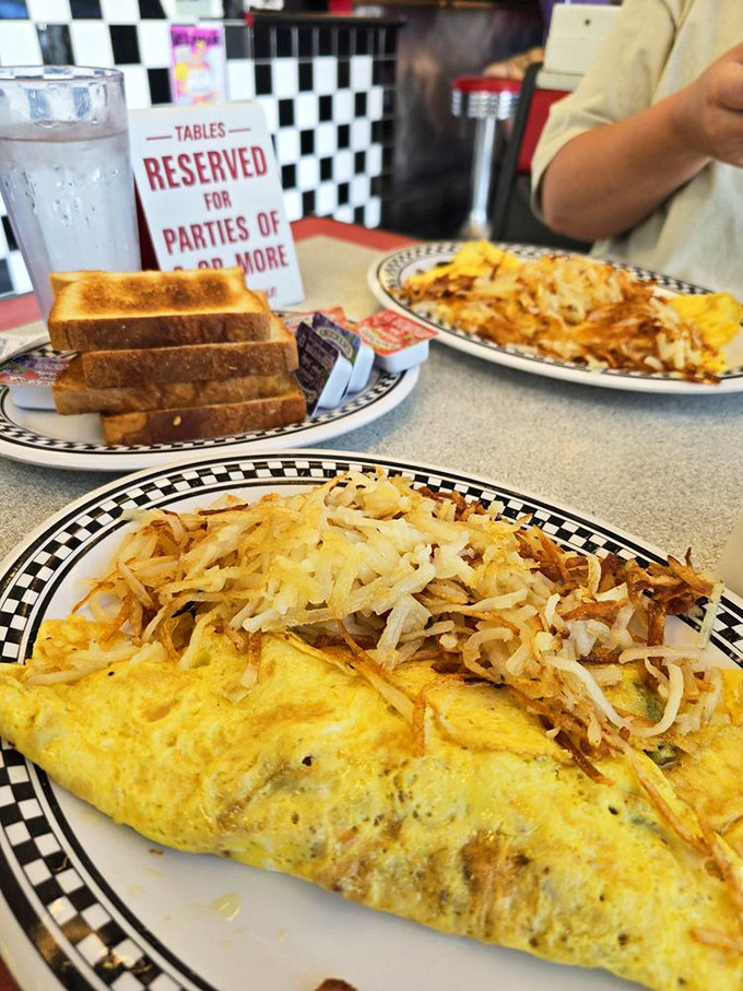 An omelet that's seen things, topped with a mountain of hash browns crispy enough to make a potato proud.
