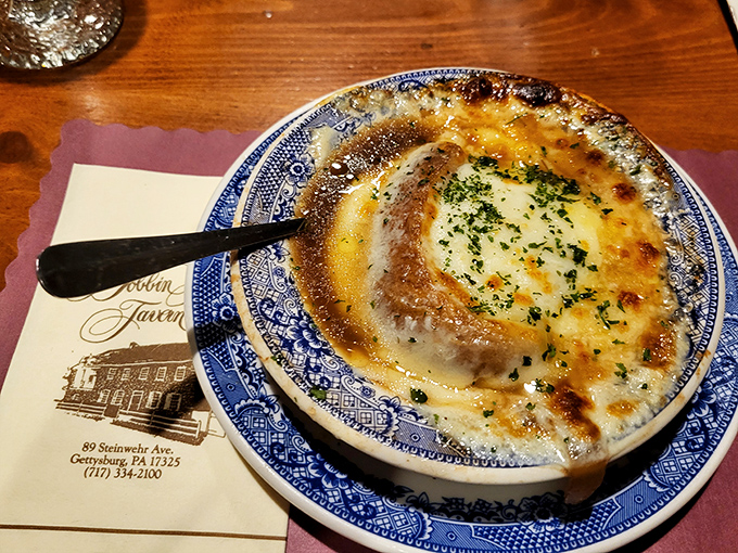 Cheese doesn't melt—it surrenders completely to this onion soup. The broth beneath that glorious crust holds secrets worth discovering with every spoonful.