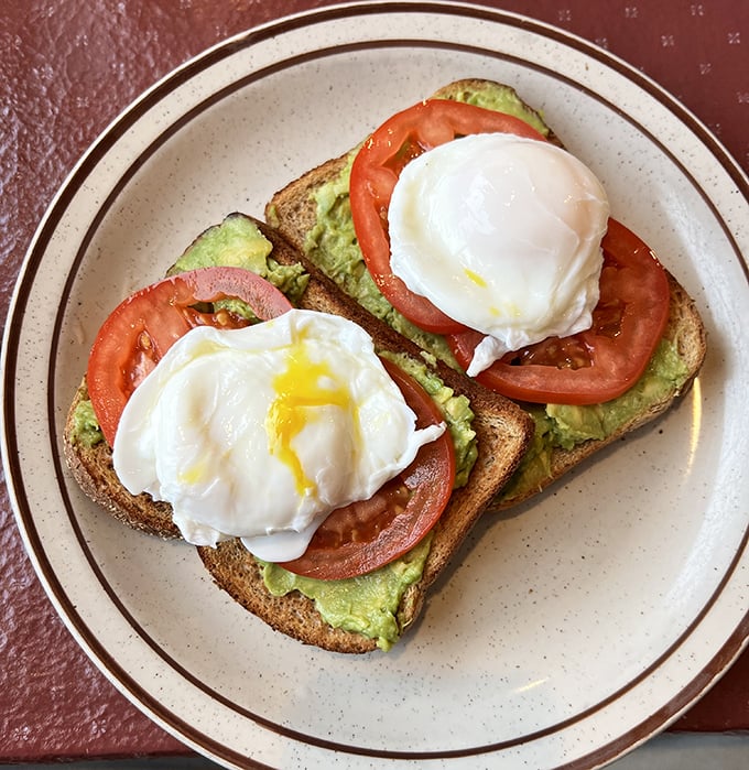Avocado toast gets the diner treatment with perfectly poached eggs that burst like flavor bombs when your fork hits them.