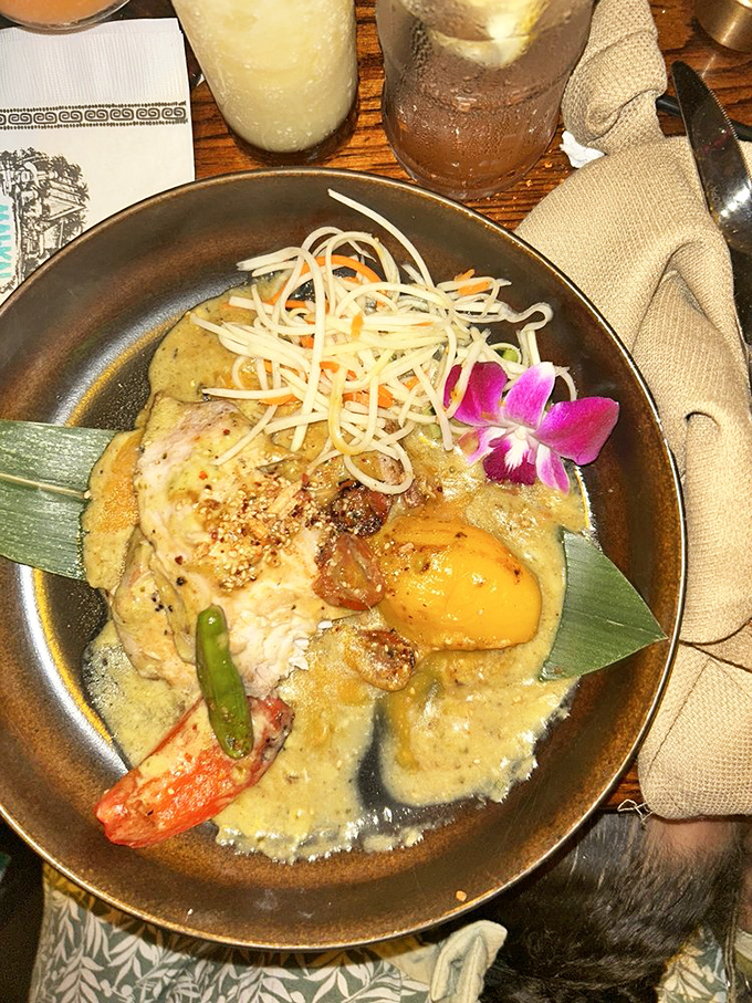 A curry that doesn't just sit on the plate&mdash;it tells a story with every spoonful, complete with a fresh orchid garnish that's almost too pretty to eat. Almost.