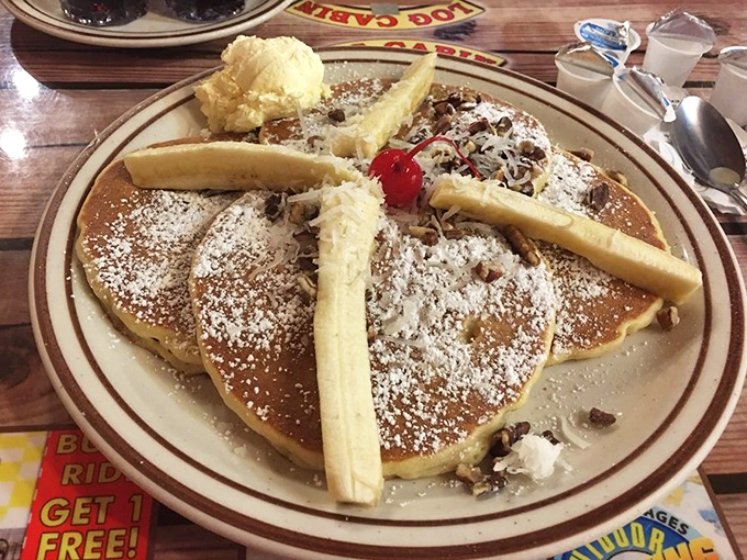 Pancakes adorned with bananas, powdered sugar, and what appears to be a cherry on top&mdash;breakfast masquerading as dessert, and nobody's complaining.