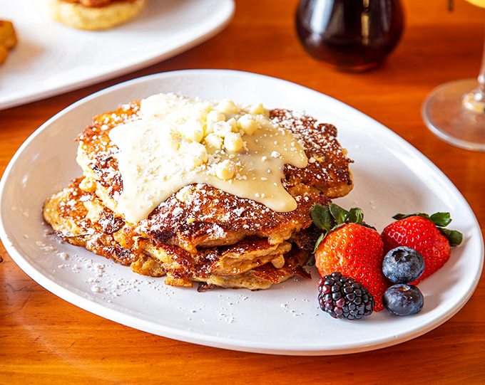 Pancakes so perfectly golden they deserve their own Instagram account, topped with a crown of berries that makes fruit feel fancy.