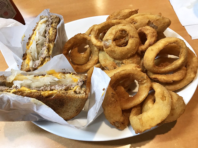 Golden onion rings form a delicious fortress around a patty melt that's achieved that magical state where bread, beef, and cheese become something transcendent.