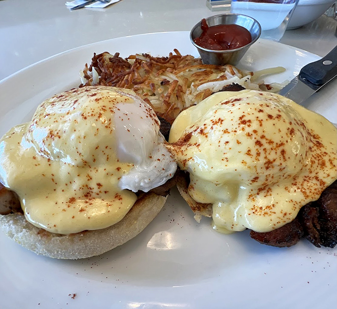 Eggs Benedict done right&mdash;with hollandaise sauce cascading like a golden waterfall. The crispy hash browns are the supporting actor who steals the scene.