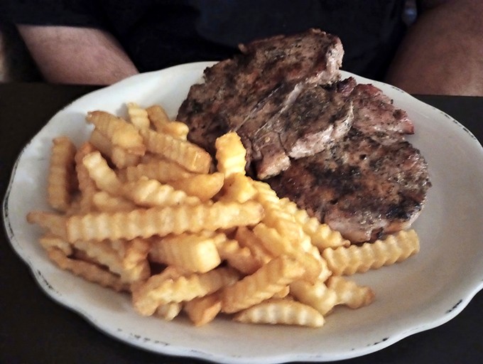 Simple pleasures done right: tender pork chops meets golden crinkle-cut fries in a pairing as timeless as Sinatra and a good Manhattan.