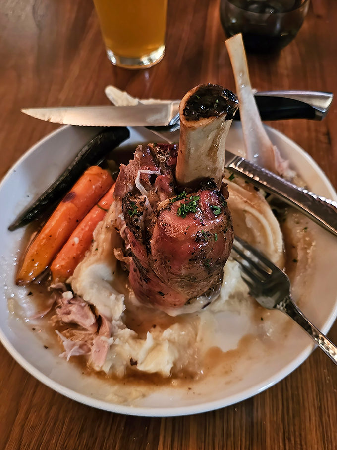 This isn't just dinner &ndash; it's architecture. The pork shank stands proudly over whipped potatoes like a meaty monument to comfort food excellence.