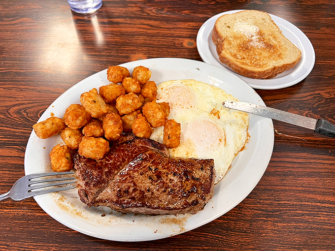 The classic steak and eggs, where a juicy cut meets perfectly crispy tater tots&mdash;proof that simplicity, done right, is culinary genius.