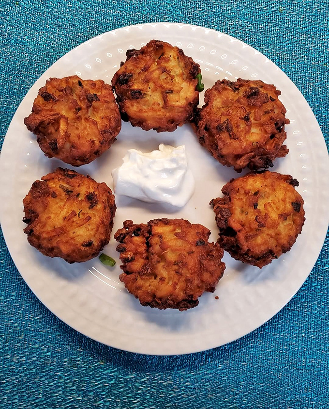 These crispy potato pancakes arrive like golden coins of comfort, each one worth its weight in satisfaction.