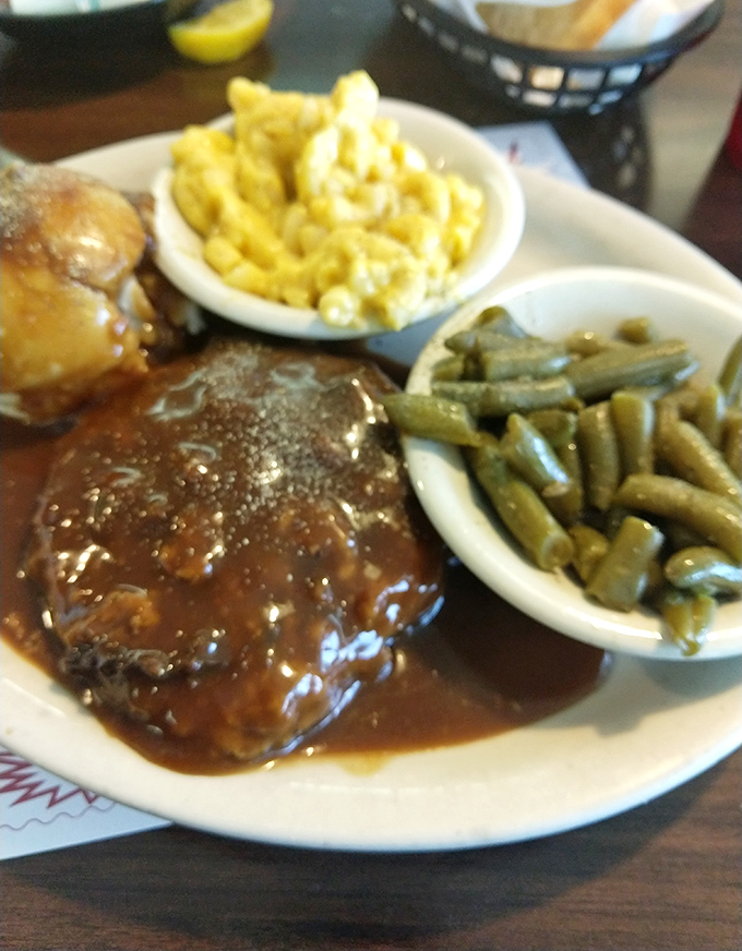 Country-style steak swimming in rich gravy alongside mac and cheese and green beans. The holy trinity of Southern comfort on one plate.