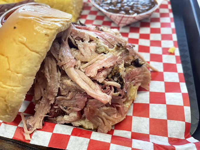 Pulled pork that surrenders at first bite, piled high on a bun that's merely a delivery system for smoky, tender perfection.
