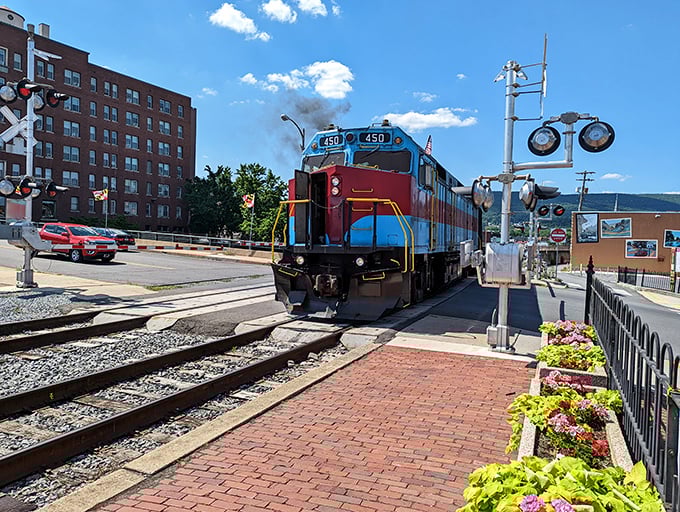 The colorful diesel waits patiently at the crossing, like a well-dressed guest arriving fashionably early to the party. All aboard for memories in the making!
