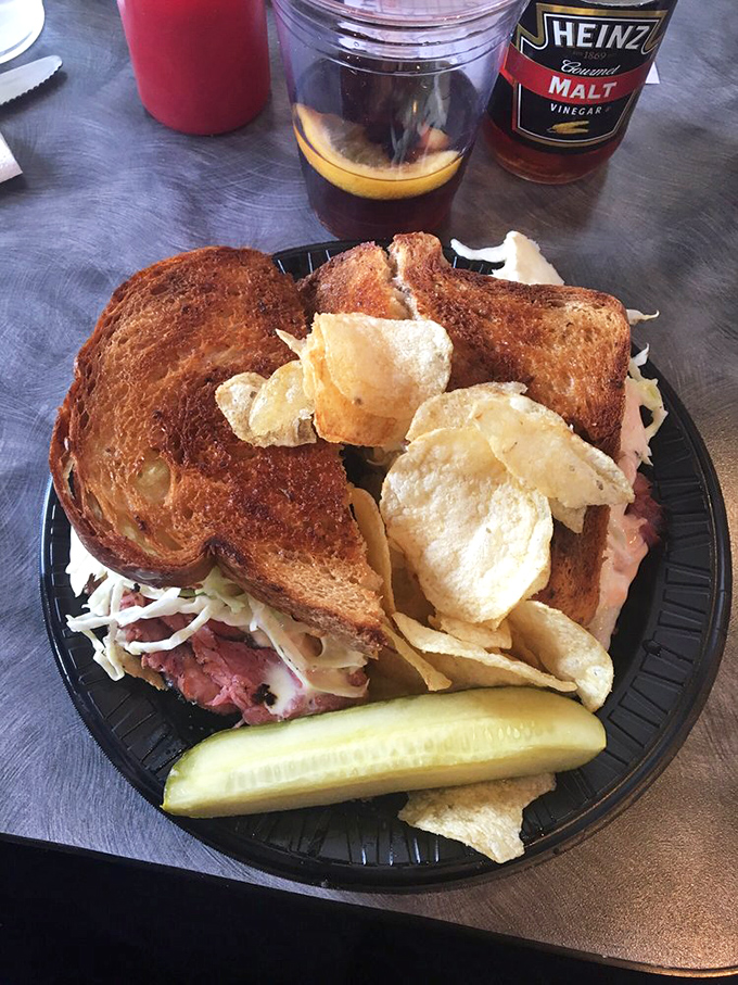 A sandwich isn't just lunch—it's architecture. This towering creation comes with chips and a pickle, because balance matters.