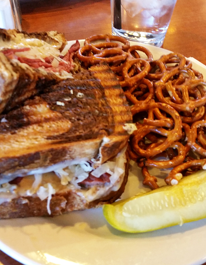 A proper Reuben demands respect—and napkins. This sandwich, with its perfect toast marks and pretzel sidekick, is practically winking at you.