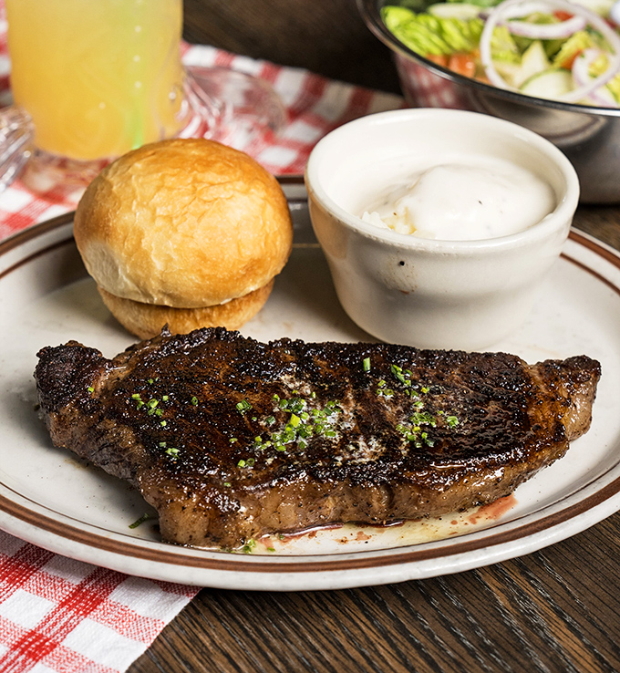 A perfectly seared ribeye that would make carnivores weep with joy, accompanied by a bun that knows its supporting role.