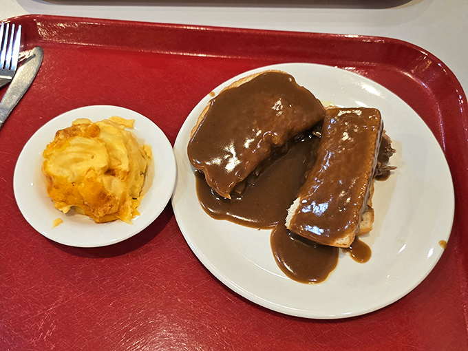 The roast beef sandwich, bathed in rich gravy, sits like royalty on its throne of white china, surrounded by its loyal court of sides.
