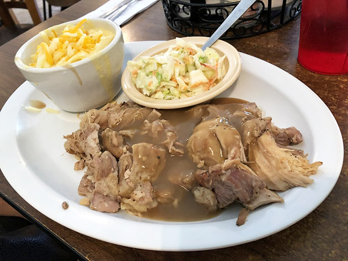 Tender roast pork swimming in savory gravy with mac and cheese and coleslaw &ndash; Southern comfort on a plate that whispers, "Nap time soon."