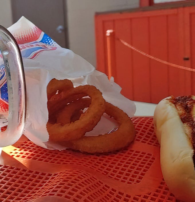 Golden halos of onion ring perfection that shatter with a satisfying crunch, revealing sweet onion centers that practically melt on your tongue.