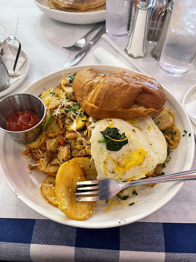 Breakfast potatoes mingle with fresh vegetables and salmon in this hearty hash, crowned with a perfectly cooked egg that's just waiting to be broken.