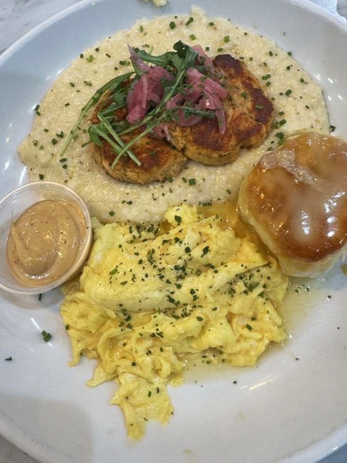 Salmon cakes nestled on a cloud of grits with eggs and a honey butter biscuit&mdash;proof that brunch isn't just a meal, it's an art form.