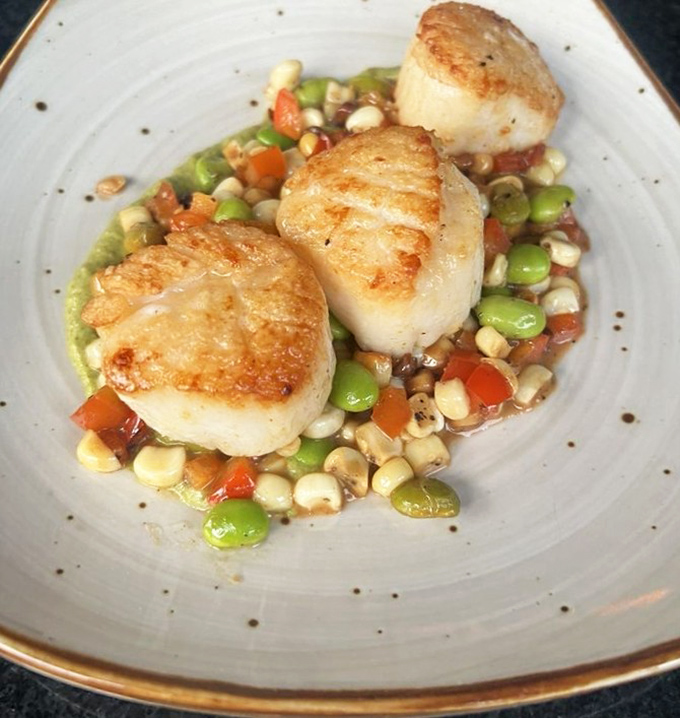 These golden-seared scallops sitting pretty on a colorful succotash aren't just seafood&mdash;they're little pillows of ocean sweetness that practically melt on contact.