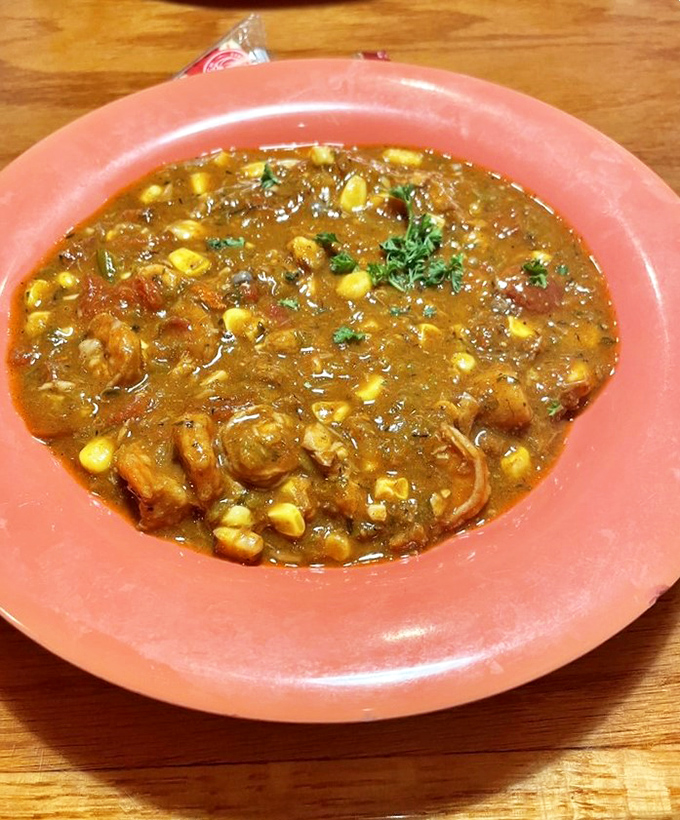 A coral-colored bowl cradles seafood gumbo that looks like it contains all the secrets of the Gulf in one steaming, savory spoonful.