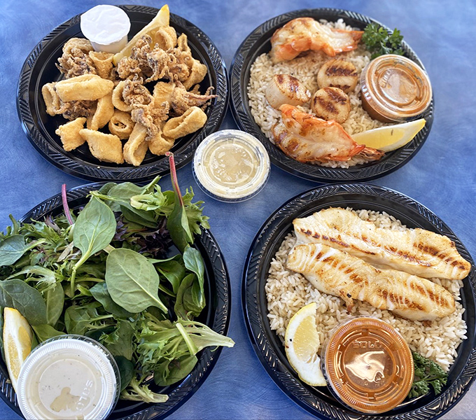 The seafood United Nations! Fried calamari, grilled shrimp, fresh fish, and vibrant greens create a diplomatic summit of flavors on these plates.
