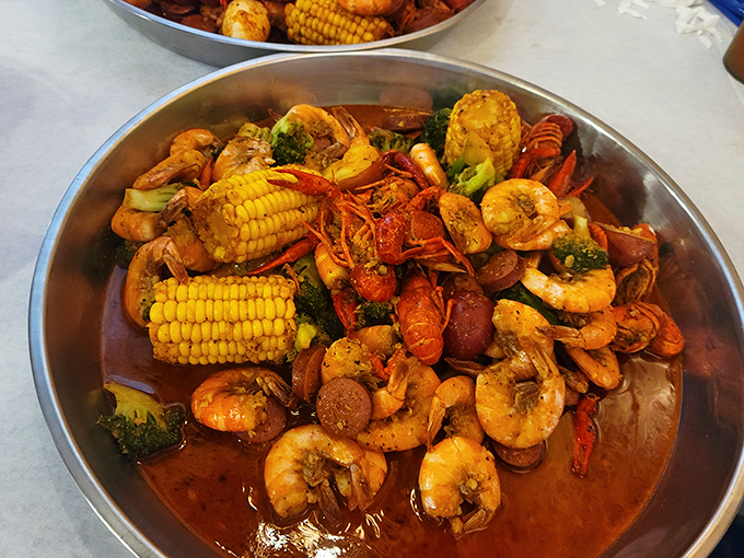 The main event arrives! A glorious medley of shrimp, crawfish, corn, and sausage swimming in spiced glory&mdash;proof that the best parties happen in metal bowls.
