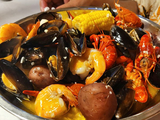 A metal bowl of oceanic harmony where mussels, crawfish, and corn hold their underwater reunion in seasoned butter.