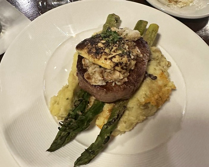 Steak Oscar &ndash; where land meets sea in perfect harmony. That filet mignon looks like it's wearing its Sunday best with crab and asparagus.
